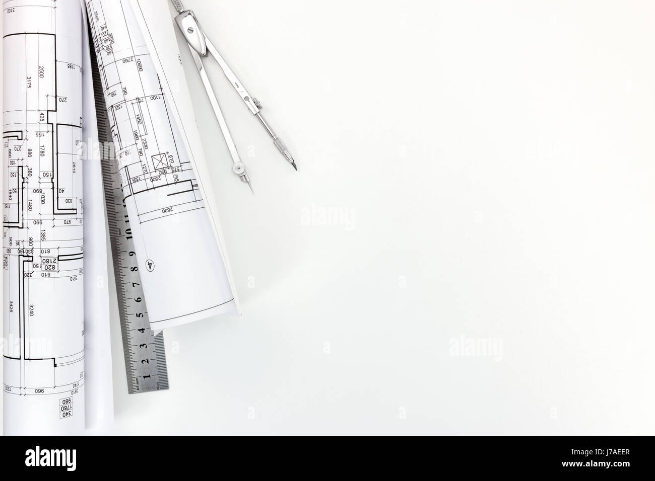 rolls of architectural blueprints and construction plans with ...