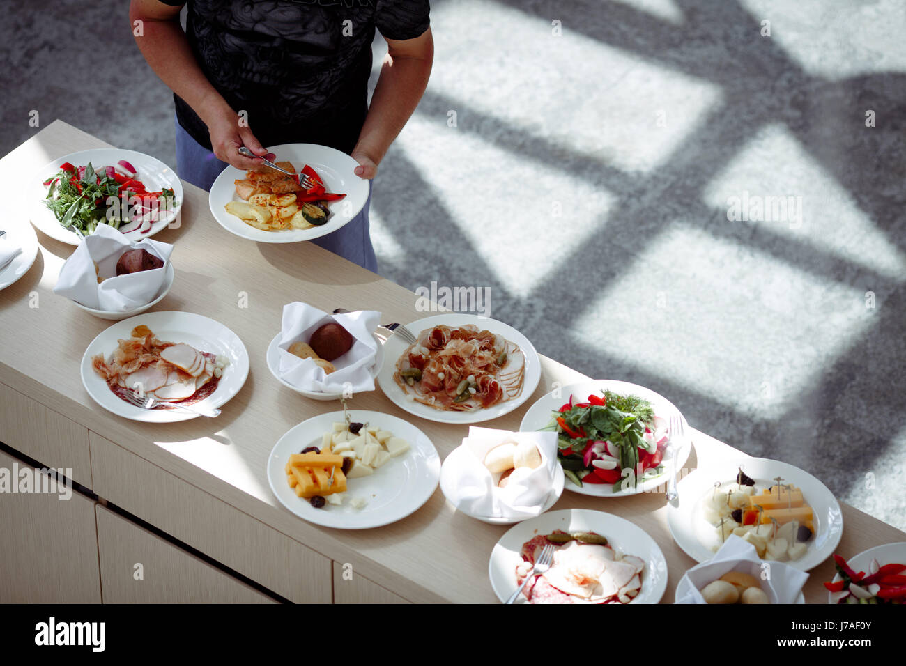 Person taking food from buffet Stock Photo - Alamy