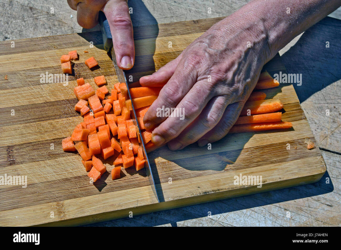 Manual cutting carrot with knife on a kitchen board Stock Photo - Alamy