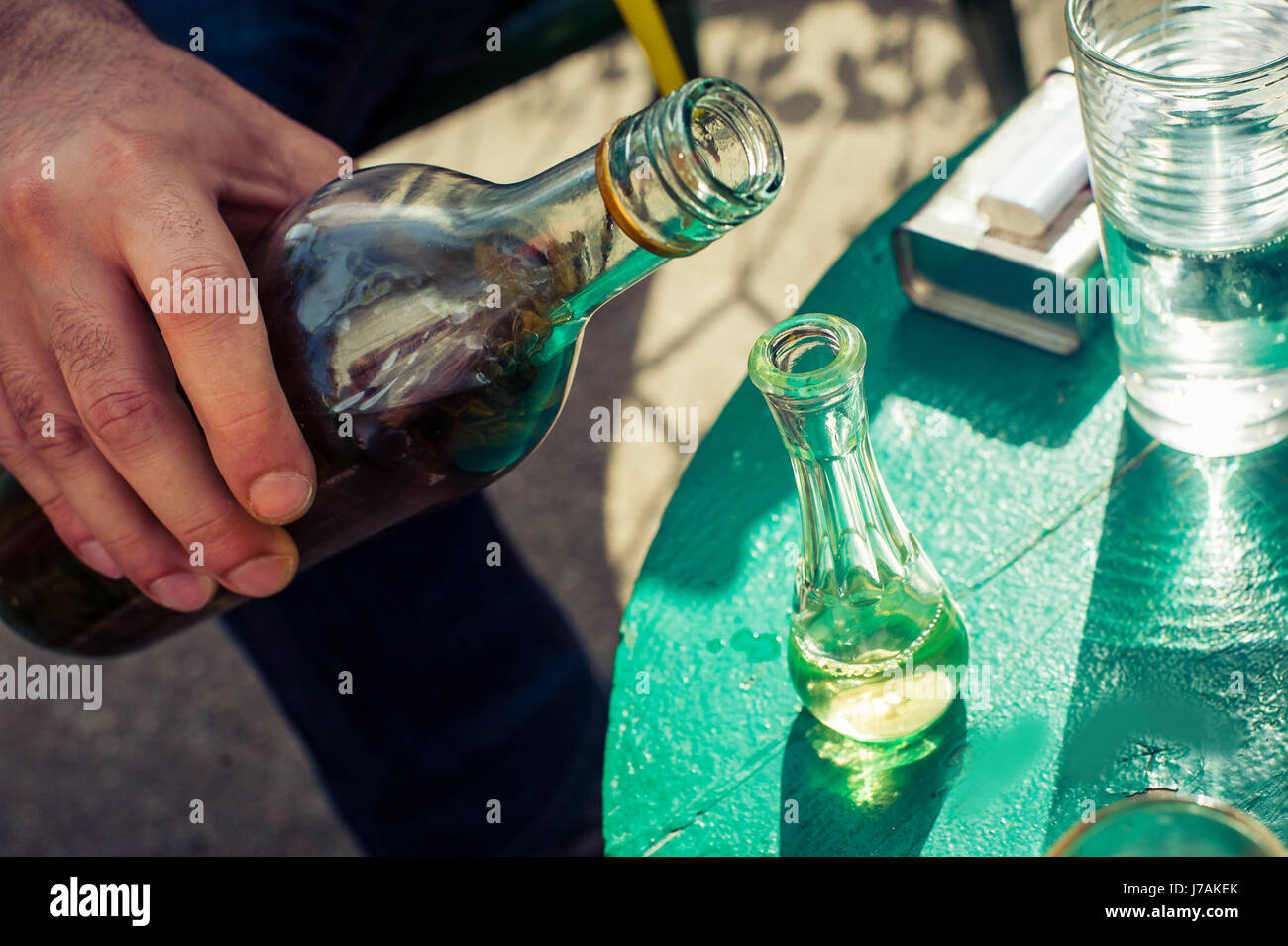 Pouring domestic brandy from bottle into glass. Outdoor Stock Photo - Alamy