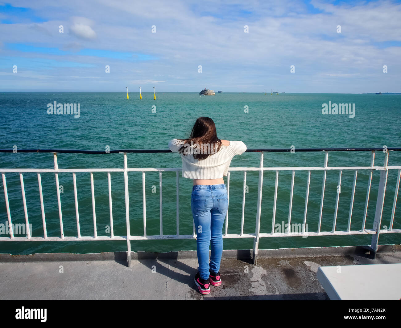 A young girl looks at the sea view during a journey across the Solent ...
