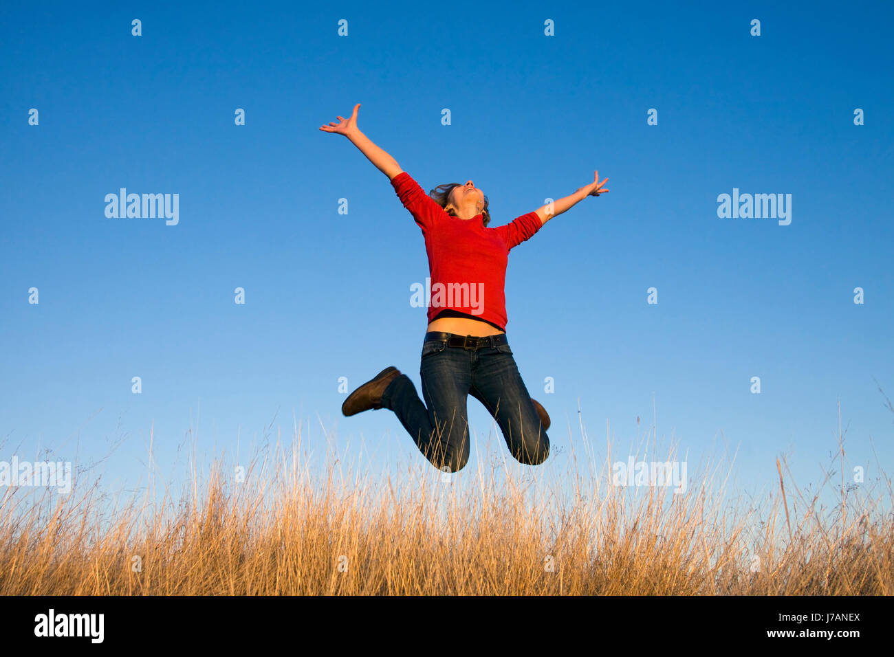 woman spring bouncing bounces hop skipping frisks jumping jump meadow ...