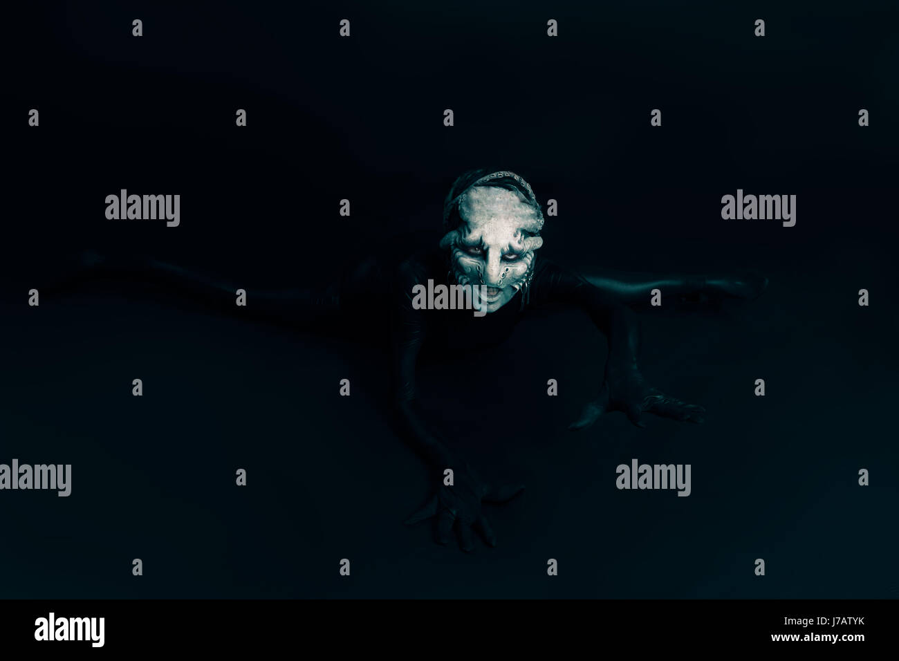 Monster or alien crawls toward you on black background Stock Photo - Alamy
