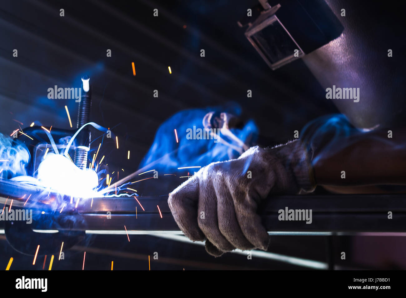close up worker welding metal with blue arc spark Stock Photo - Alamy