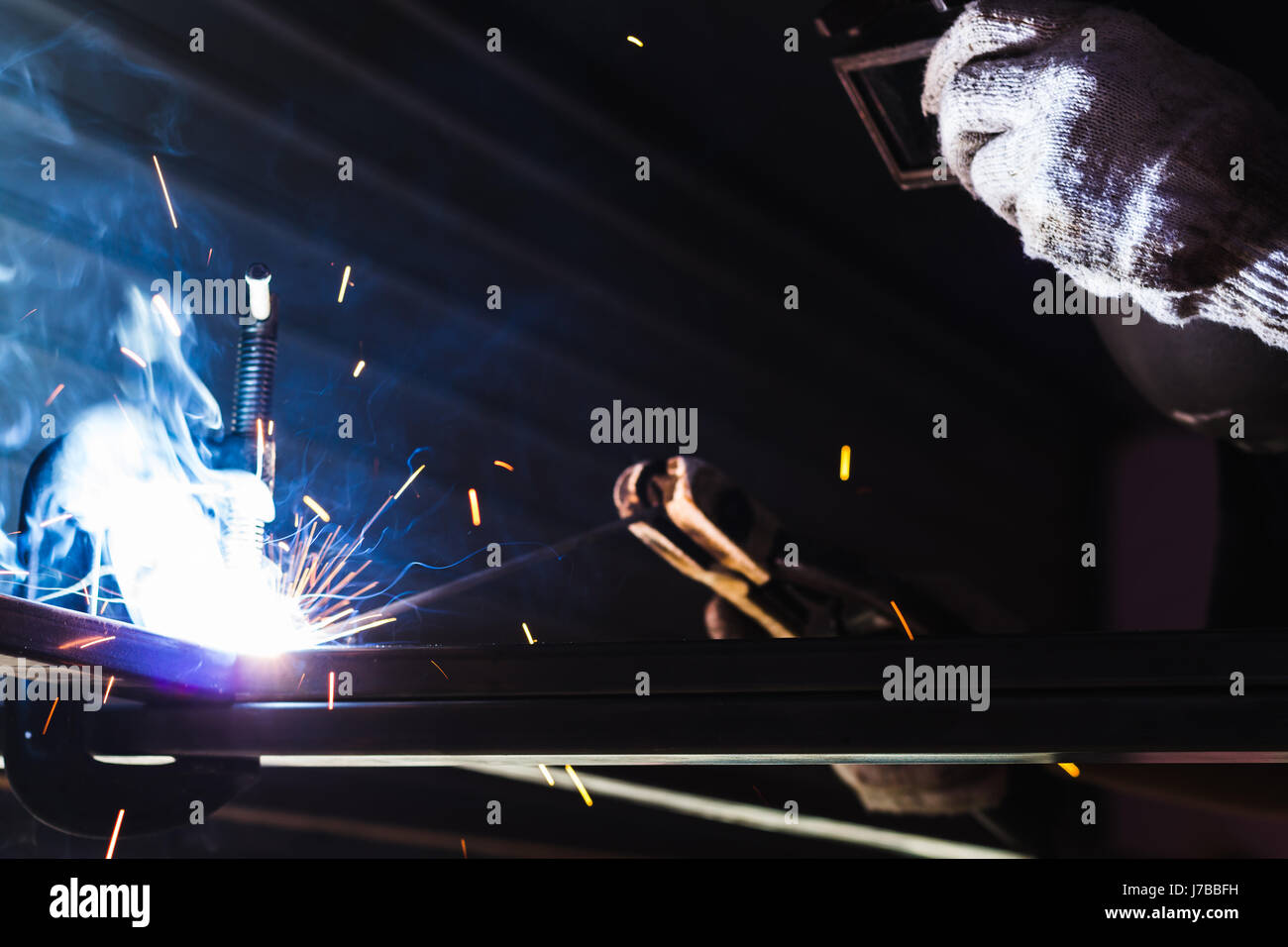 close up worker welding metal with blue arc spark Stock Photo - Alamy