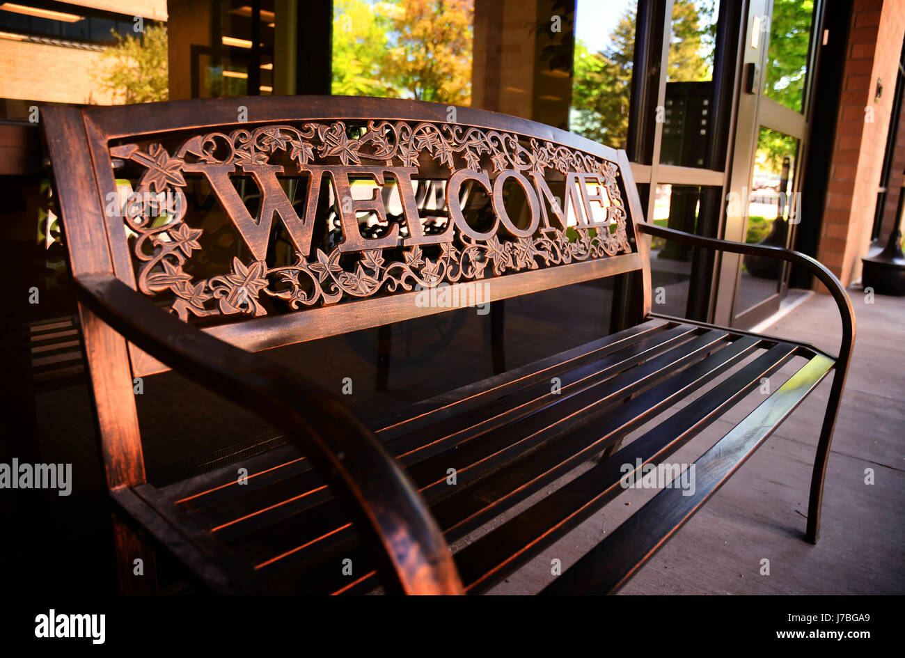 Copper welcome bench outside an office building Stock Photo - Alamy