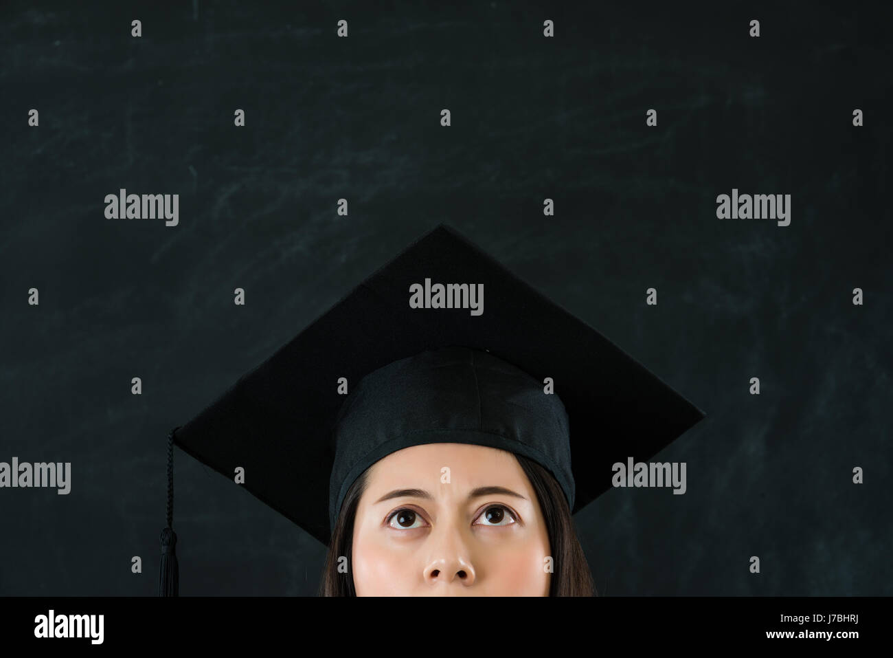 annoyed skeptical graduate looking up isolated on wall background with ...