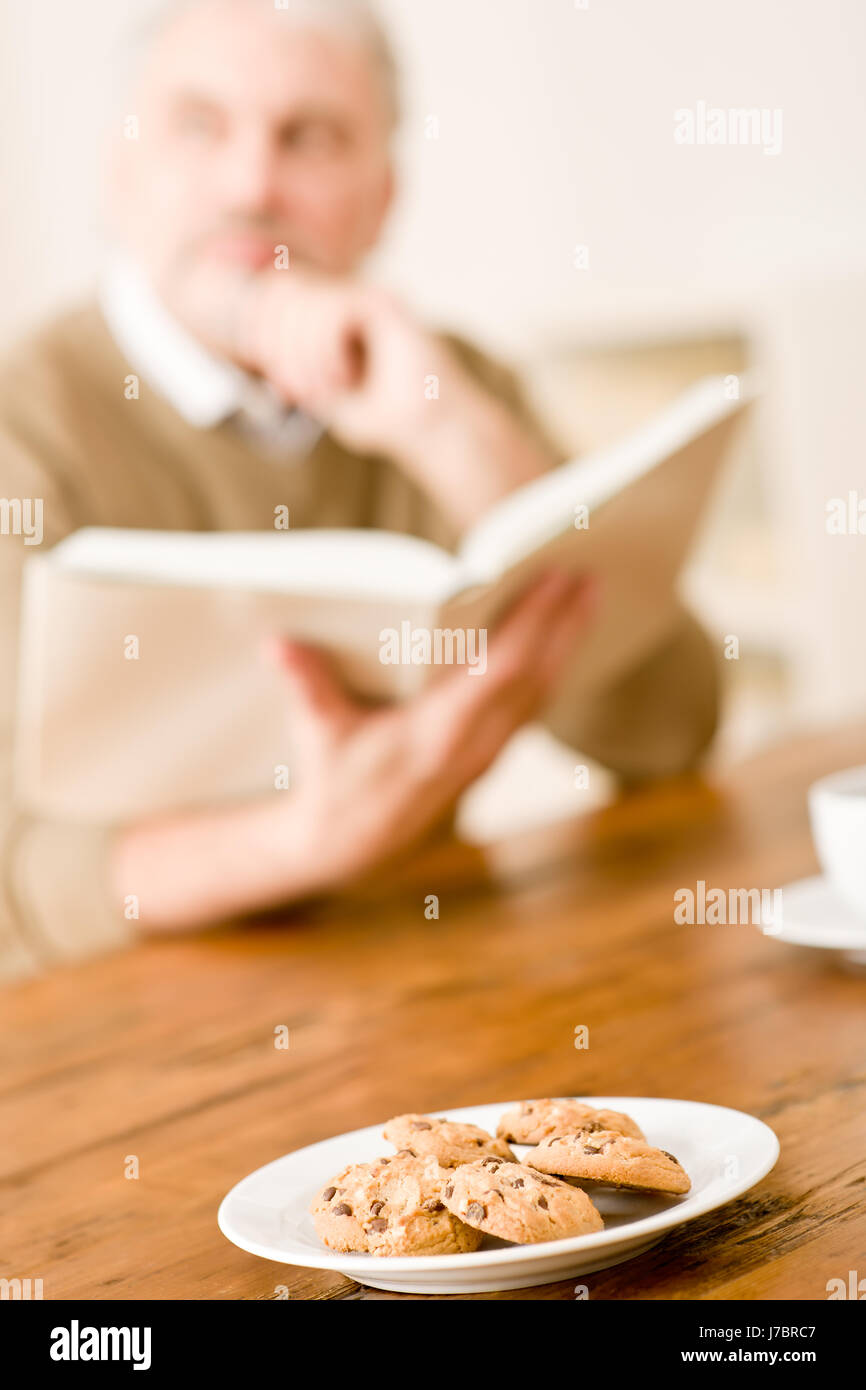 lifestyle relaxation biscuits cookies wooden table man senior senior ...