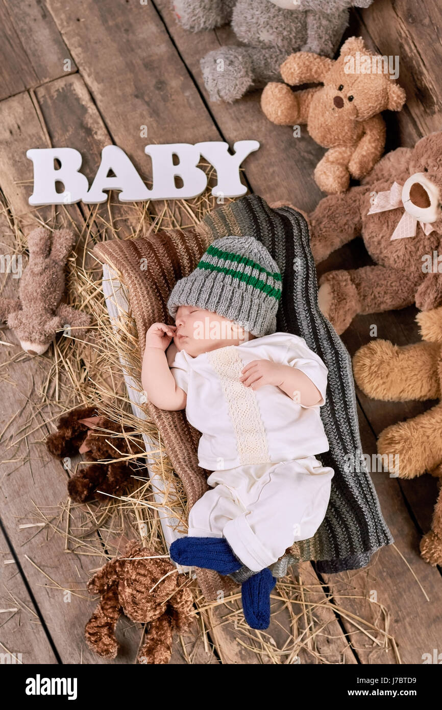 Baby and teddybears, top view. Small child lying on hay Stock Photo - Alamy