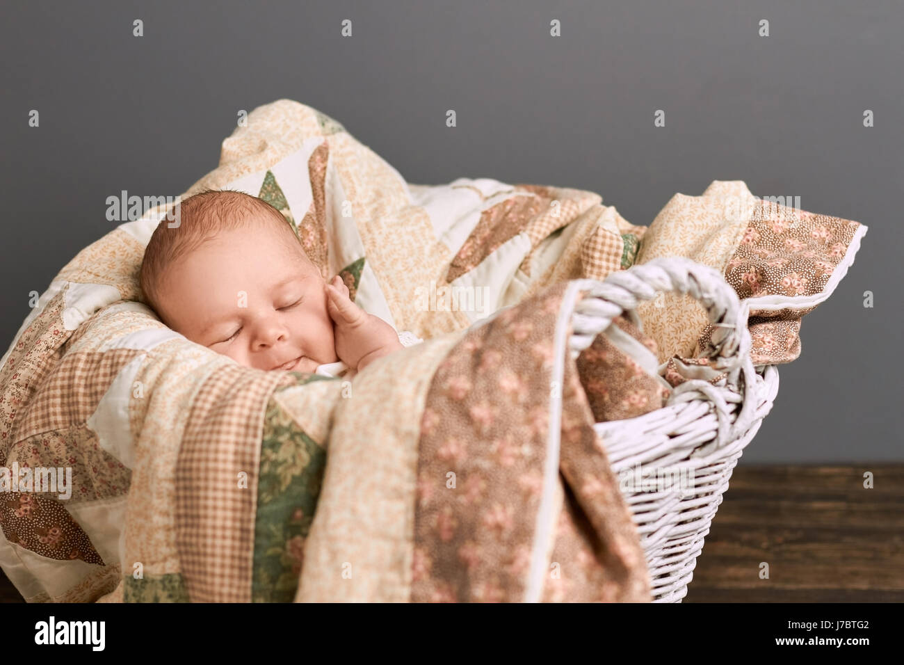 Infant boy with closed eyes. Cute kid touching his face. Baby skin care ...