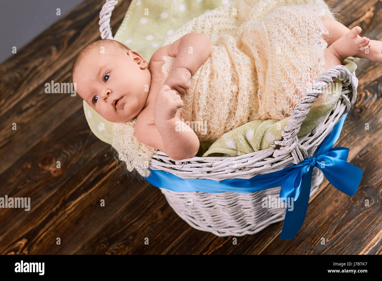 Caucasian infant in a basket. Baby boy wrapped in blanket Stock Photo ...