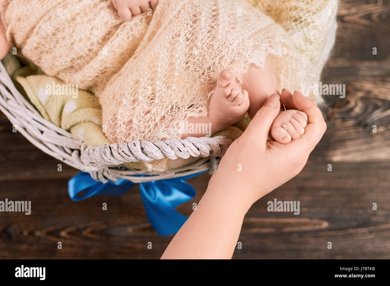 Hand holding foot of child. Little kid wrapped in blanket. Joy of ...