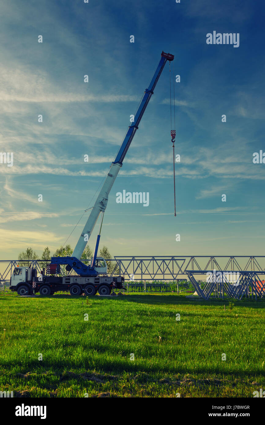 Car crane with risen telescopic boom outdoors on the construction site ...