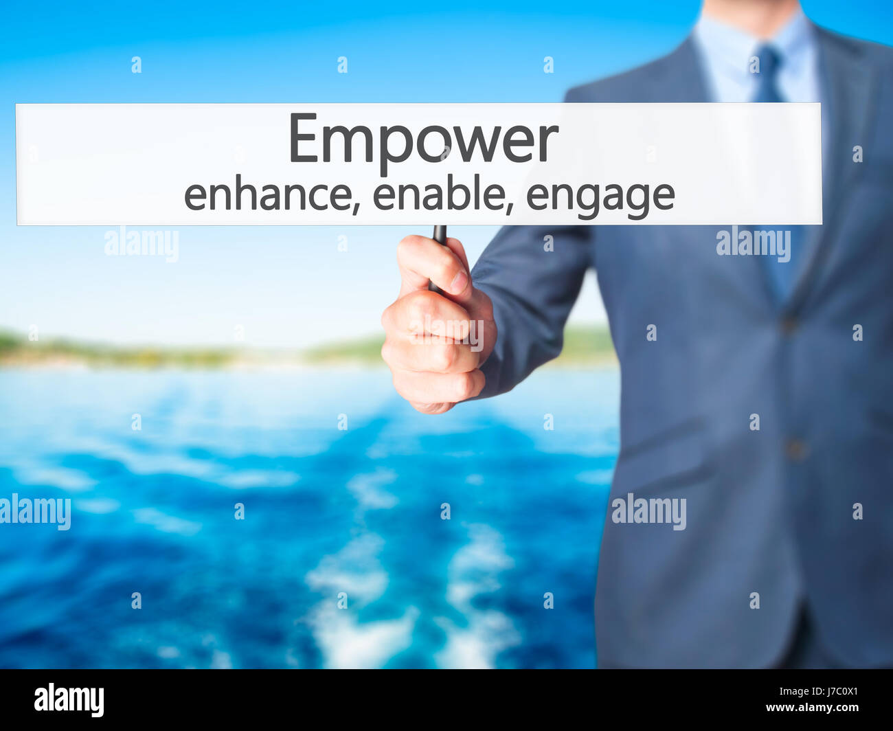 Empower enhance, enable, engage - Businessman hand holding sign ...