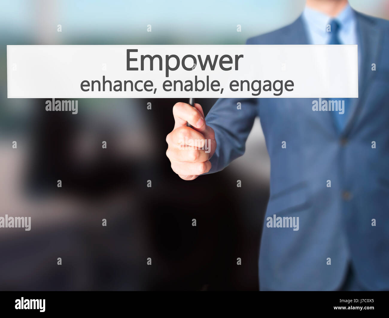Empower enhance, enable, engage - Businessman hand holding sign. Business, technology, internet ...