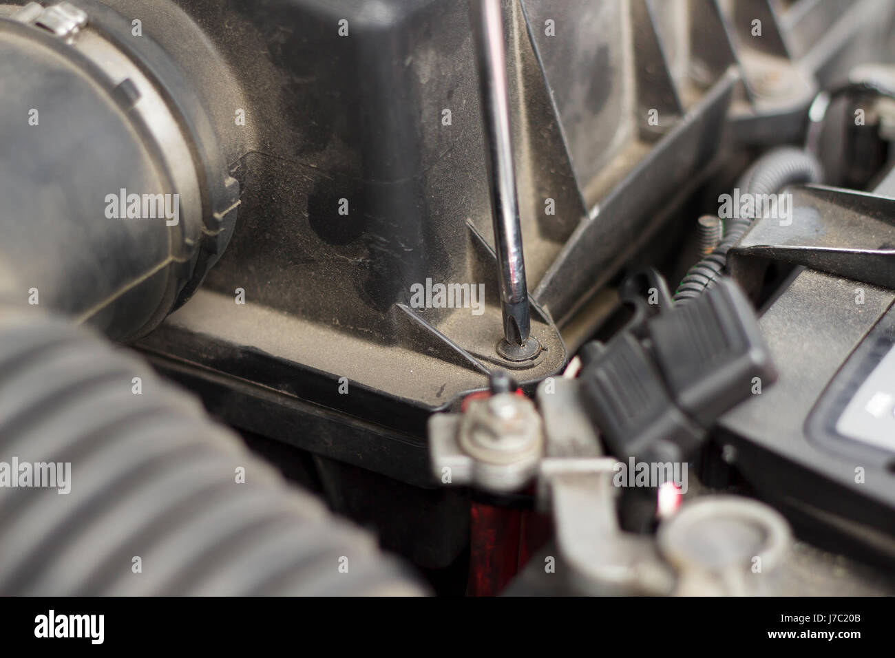 Unscrew the screw from the air filter cover with a screwdriver. The ...