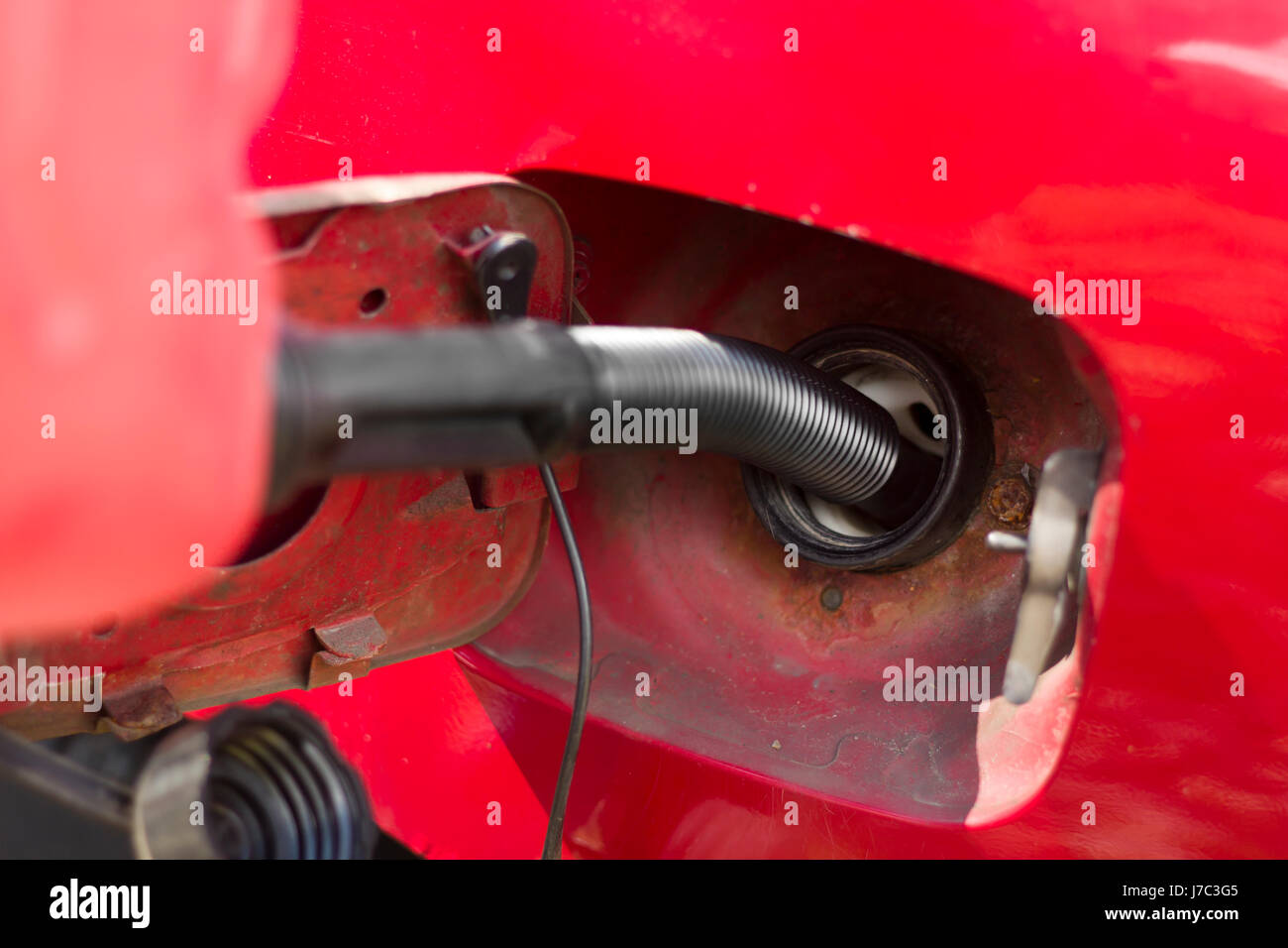 Add fuel from a plastic canister to the car's tank. Refilling fuel from ...