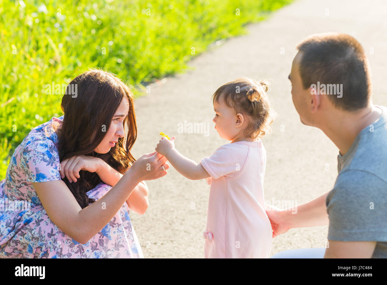 Baby daughter Giving Mother Flowers in the park Stock Photo - Alamy