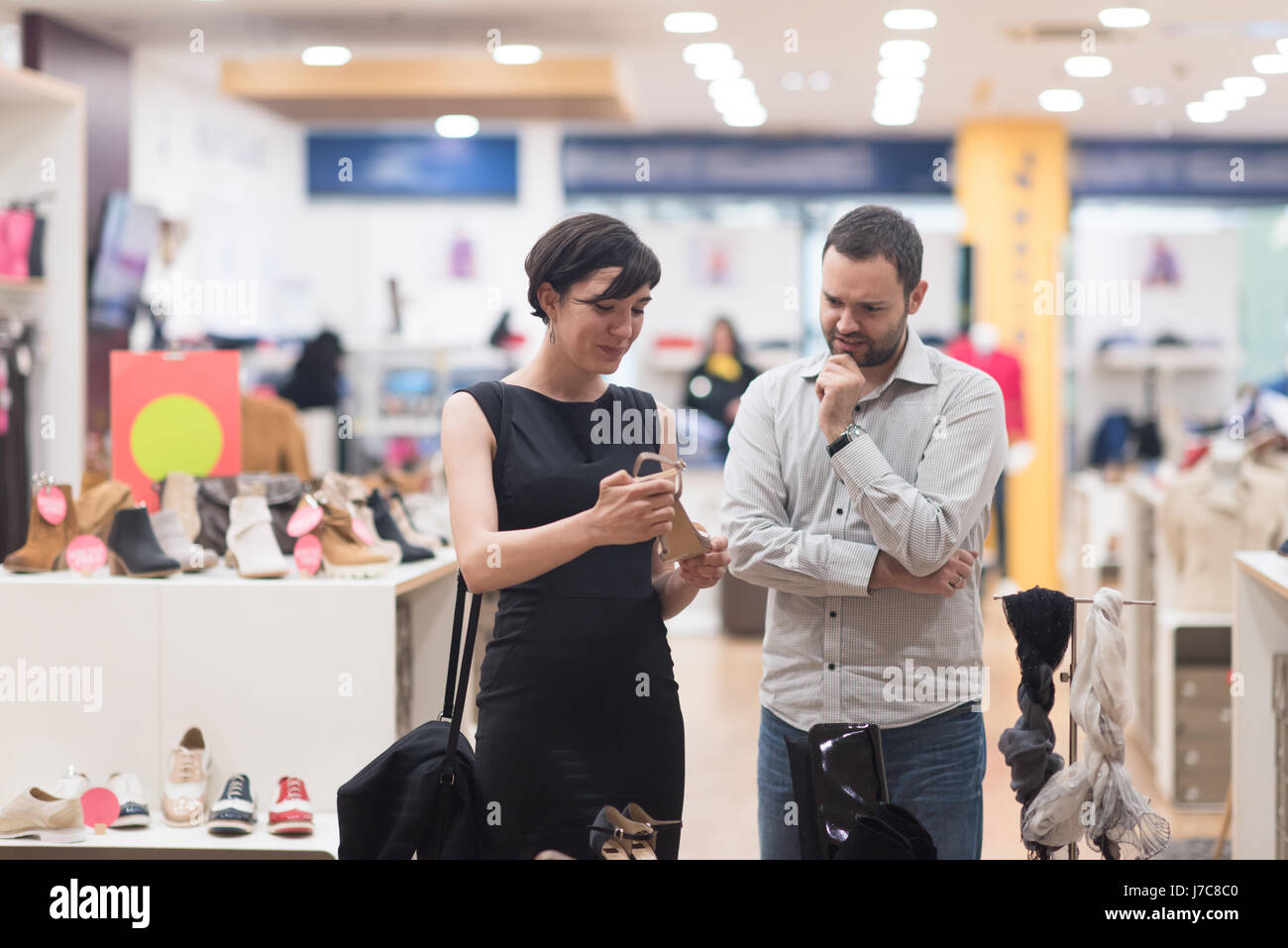 A young attractive couple changes the look with new shoes At Shoe Store ...