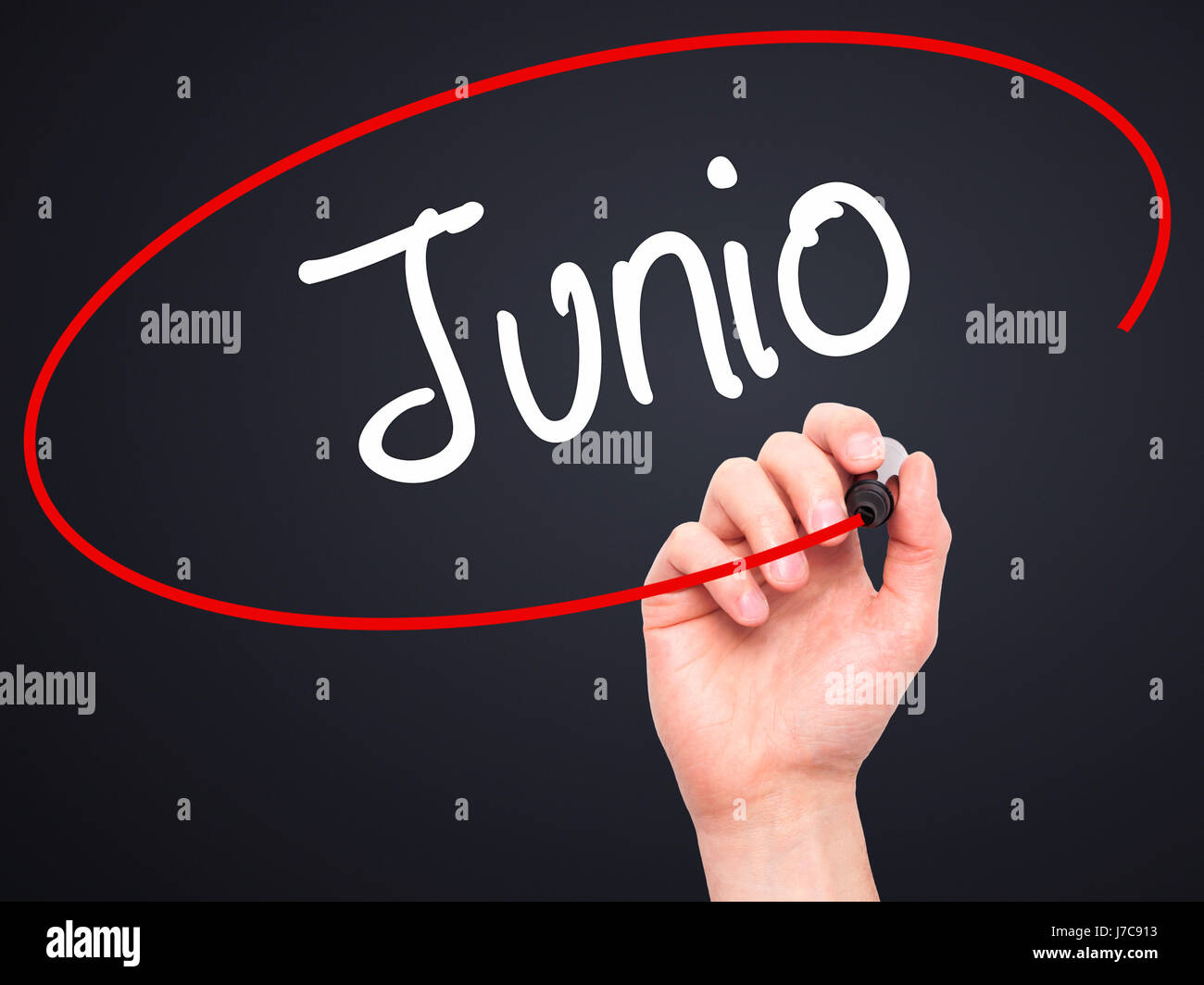 Man Hand writing Junio (June in Spanish) with black marker on visual ...