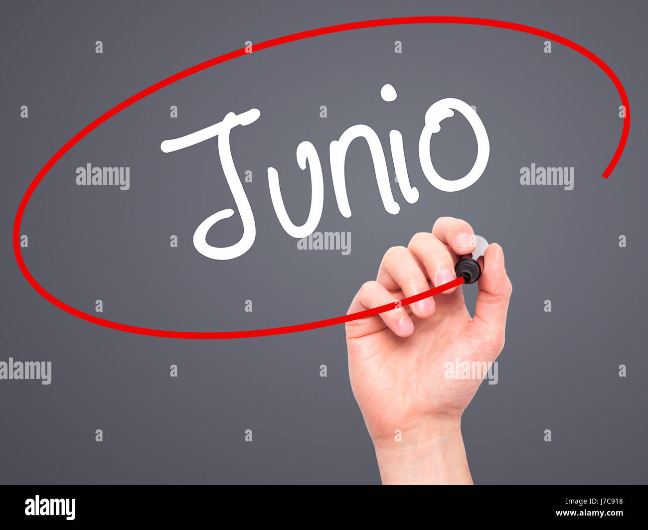 Man Hand writing Junio (June in Spanish) with black marker on visual ...