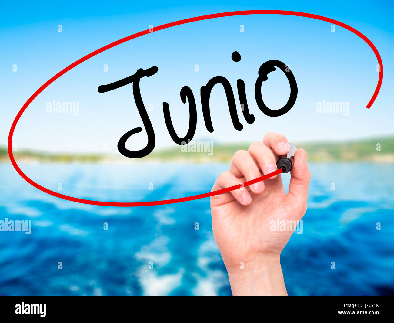 Man Hand writing Junio (June in Spanish) with black marker on visual ...