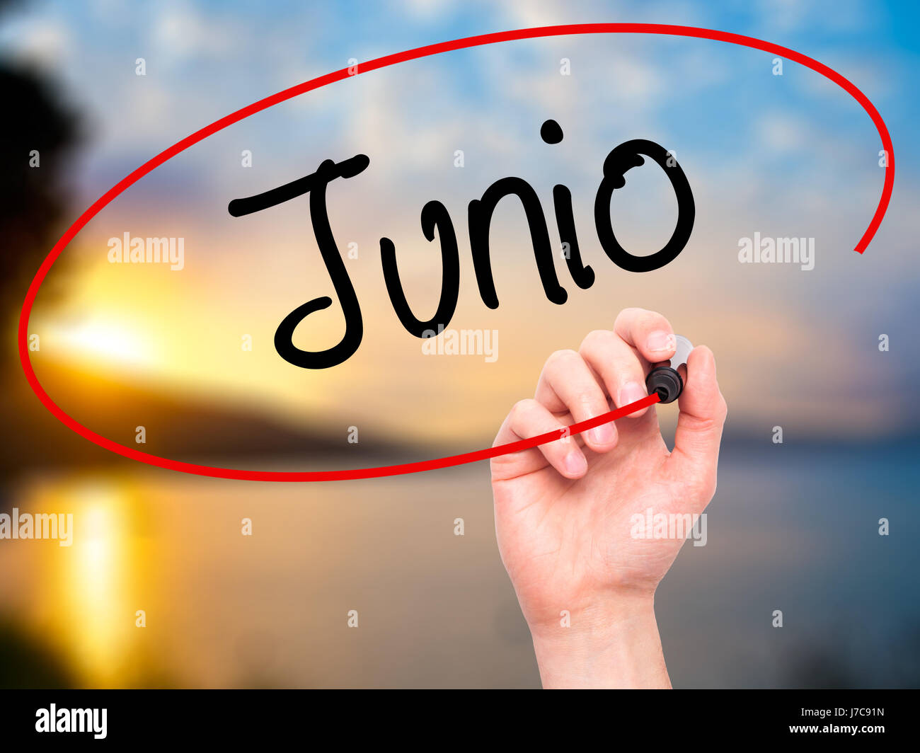 Man Hand writing Junio (June in Spanish) with black marker on visual ...