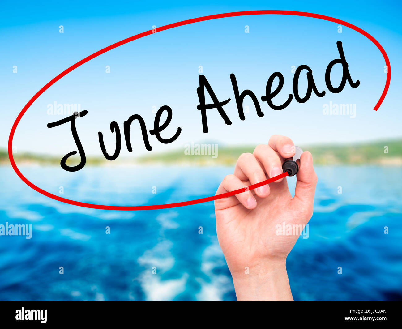 Man Hand writing June Ahead with black marker on visual screen ...