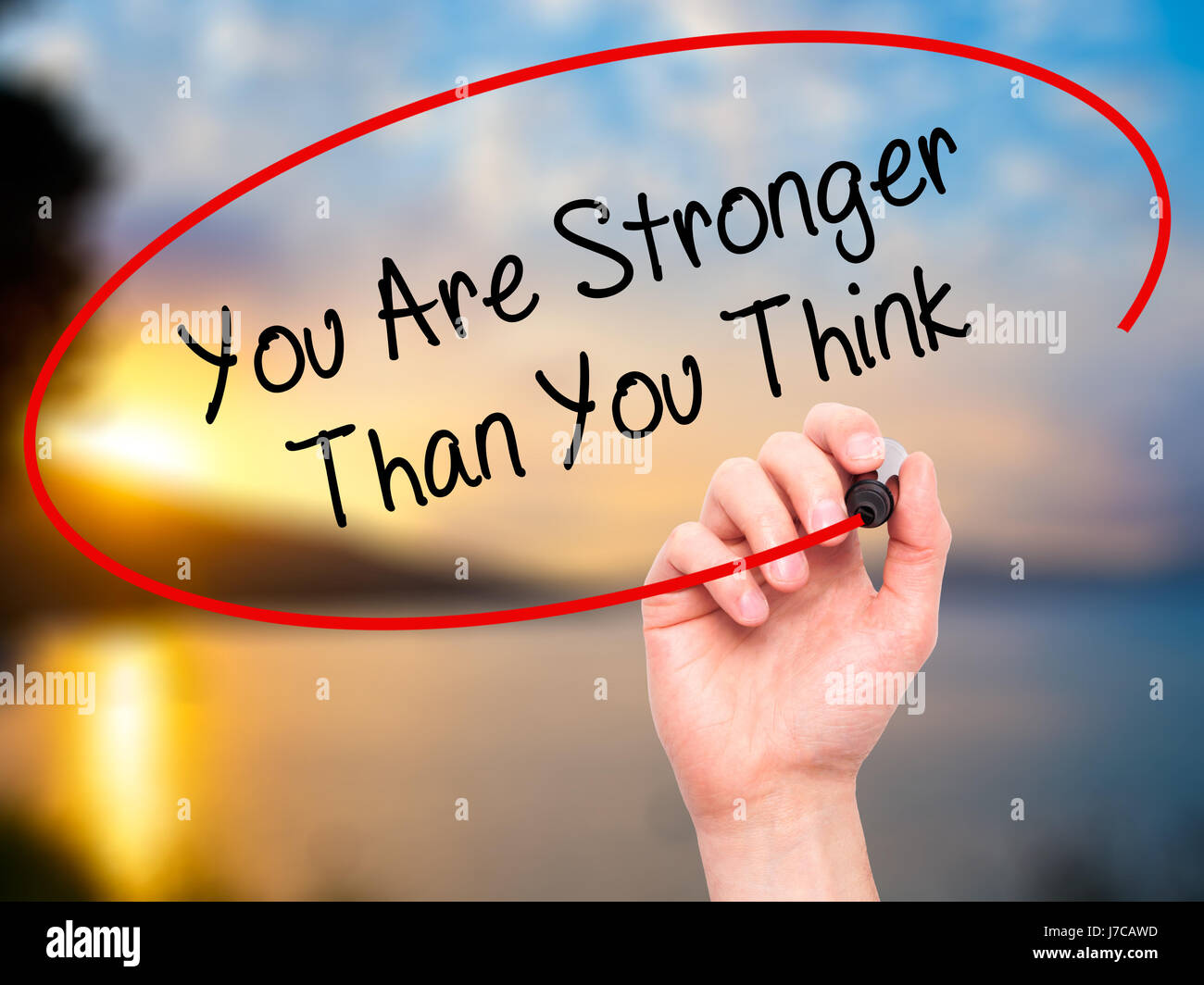 Man Hand writing You Are Stronger Than You Think with black marker on ...