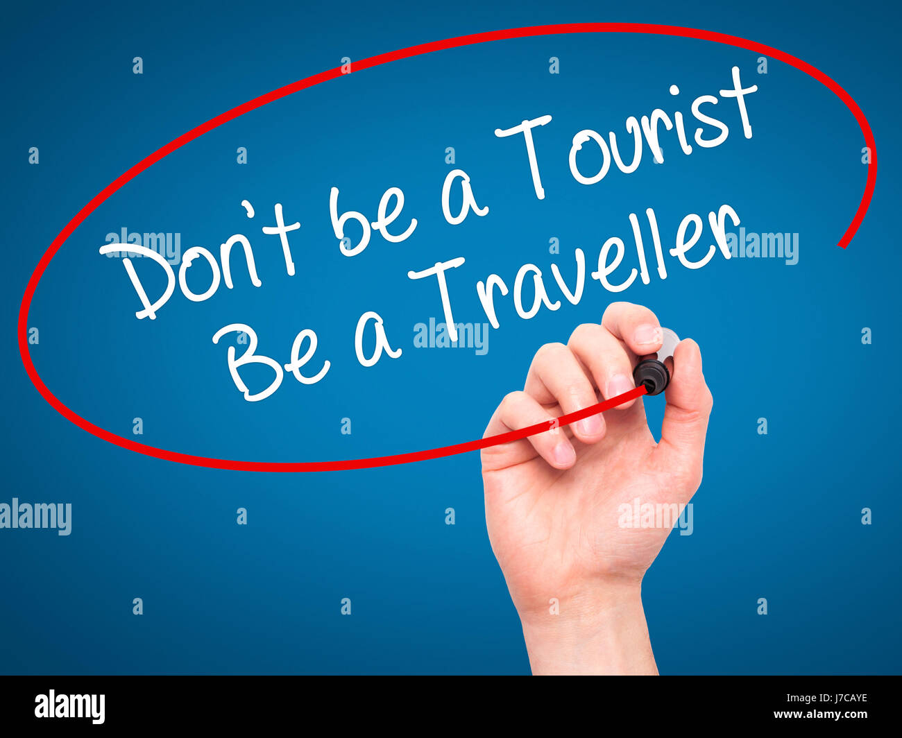 Man Hand writing Don't be a Tourist Be a Traveller with black marker on ...