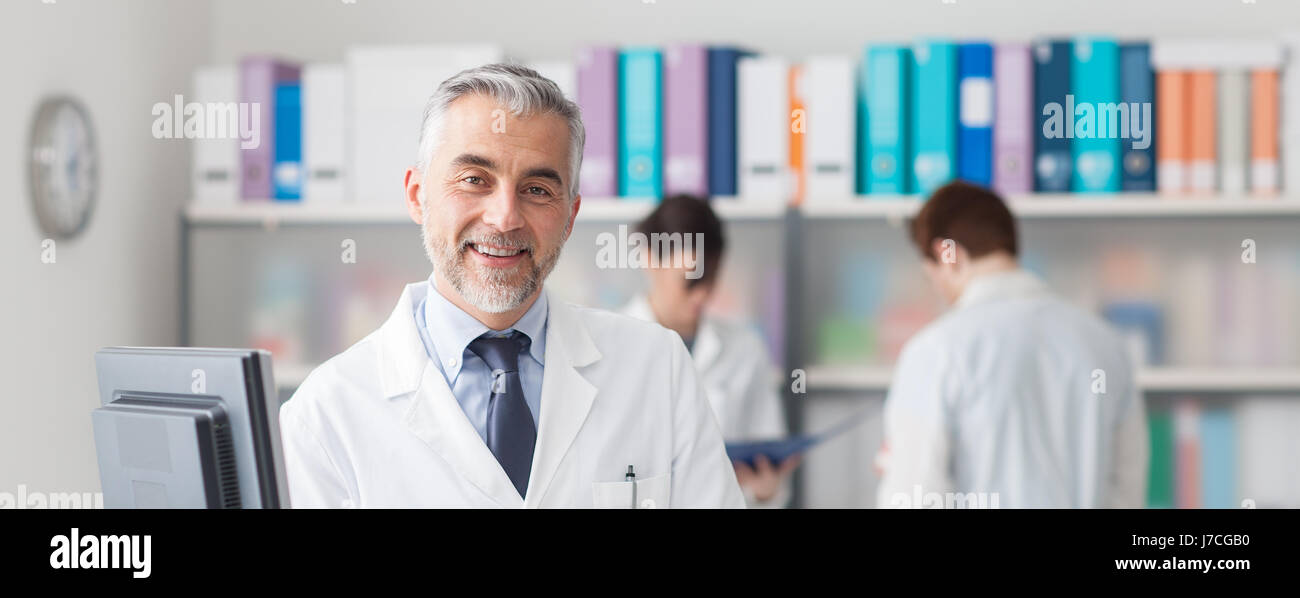 Professional smiling doctor posing at hospital, medical staff working ...