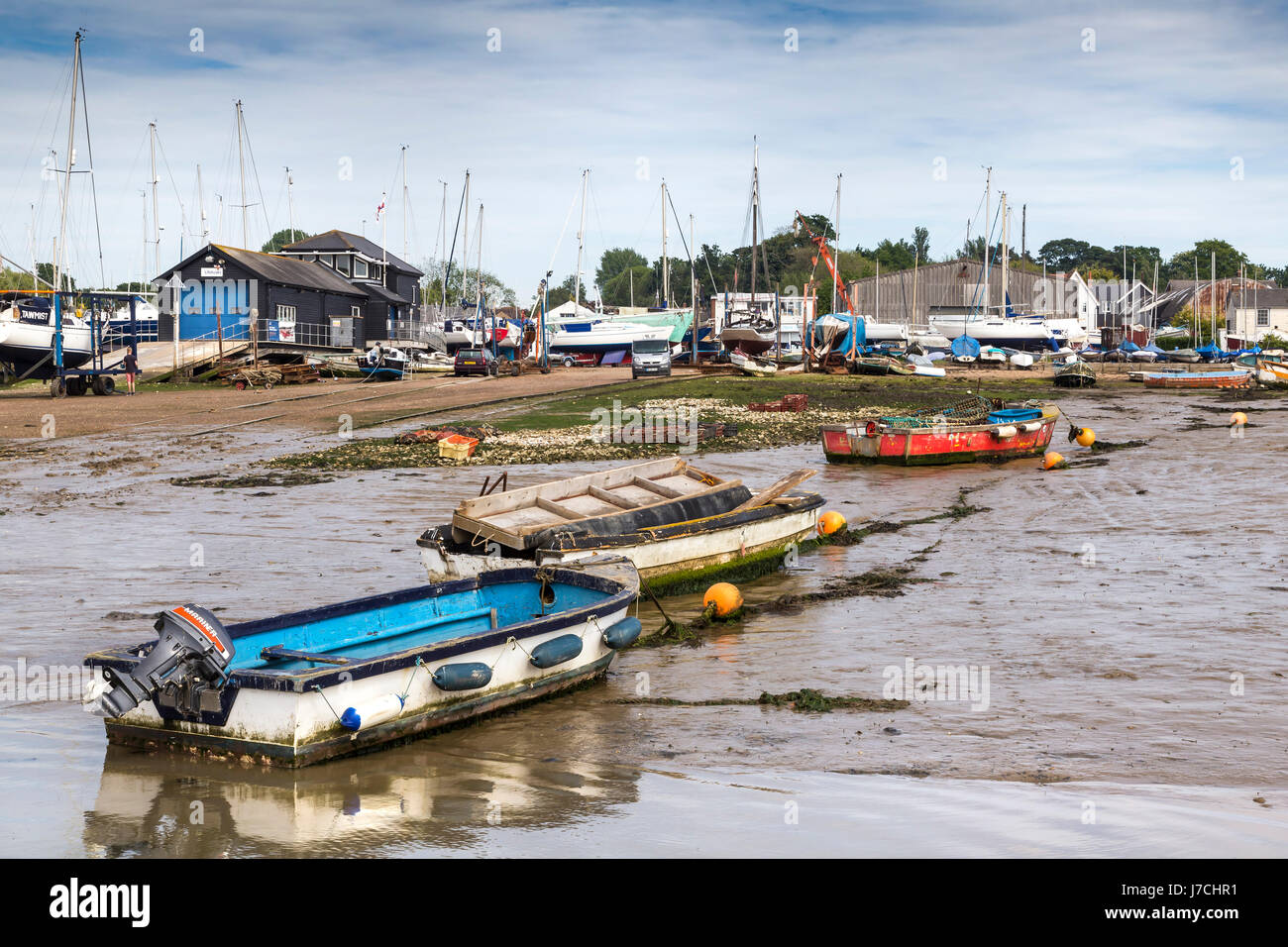 BOATS ON THE MUD AT WEST MERSEA WITH THE LIFEBOAT STATION BEHIND Stock ...