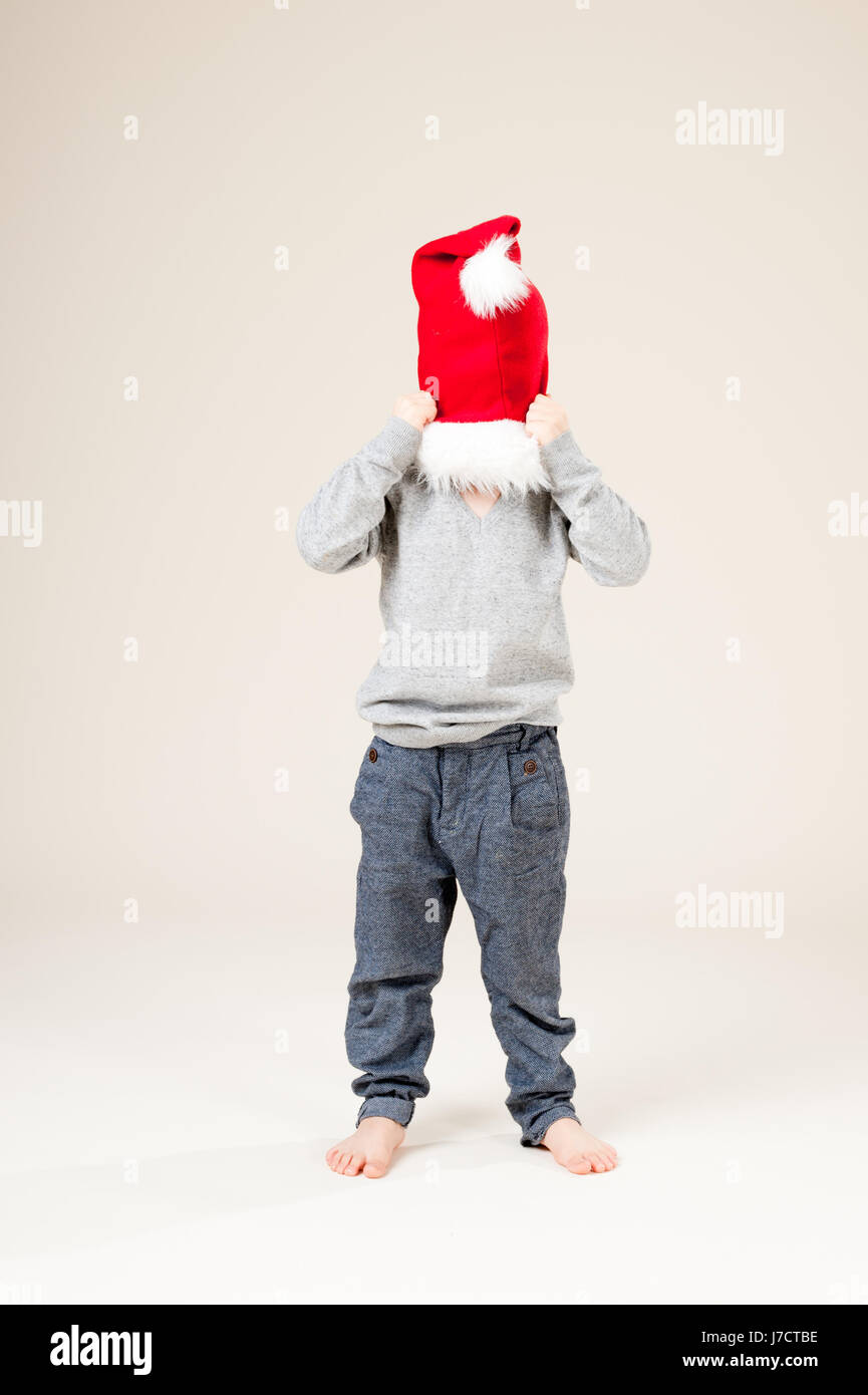 Boy hiding under Christmas hat Stock Photo - Alamy