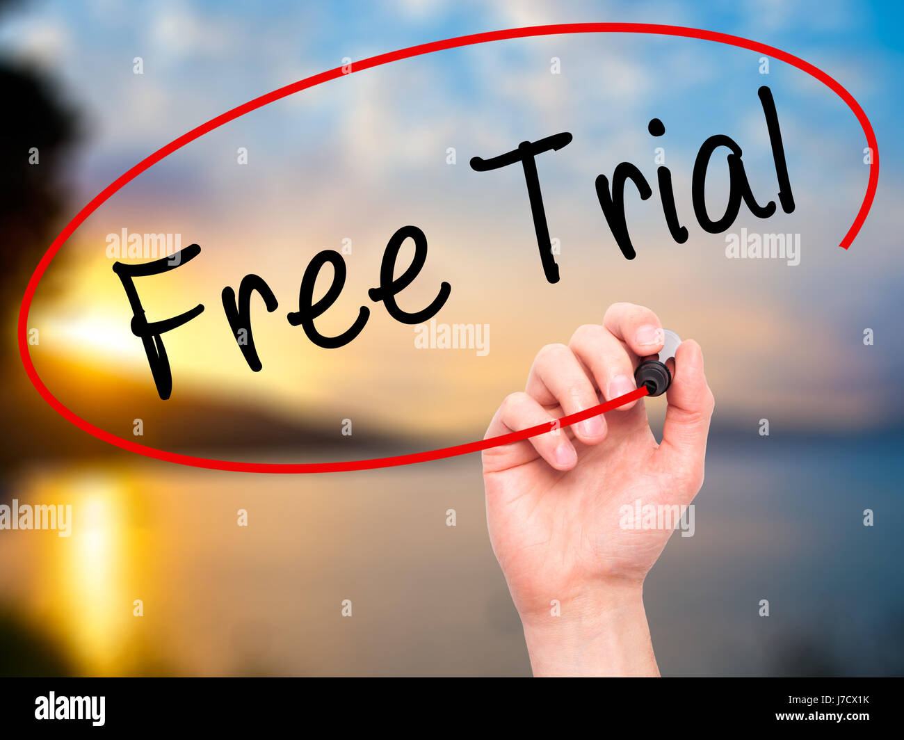 Man Hand writing Free Trial with black marker on visual screen ...