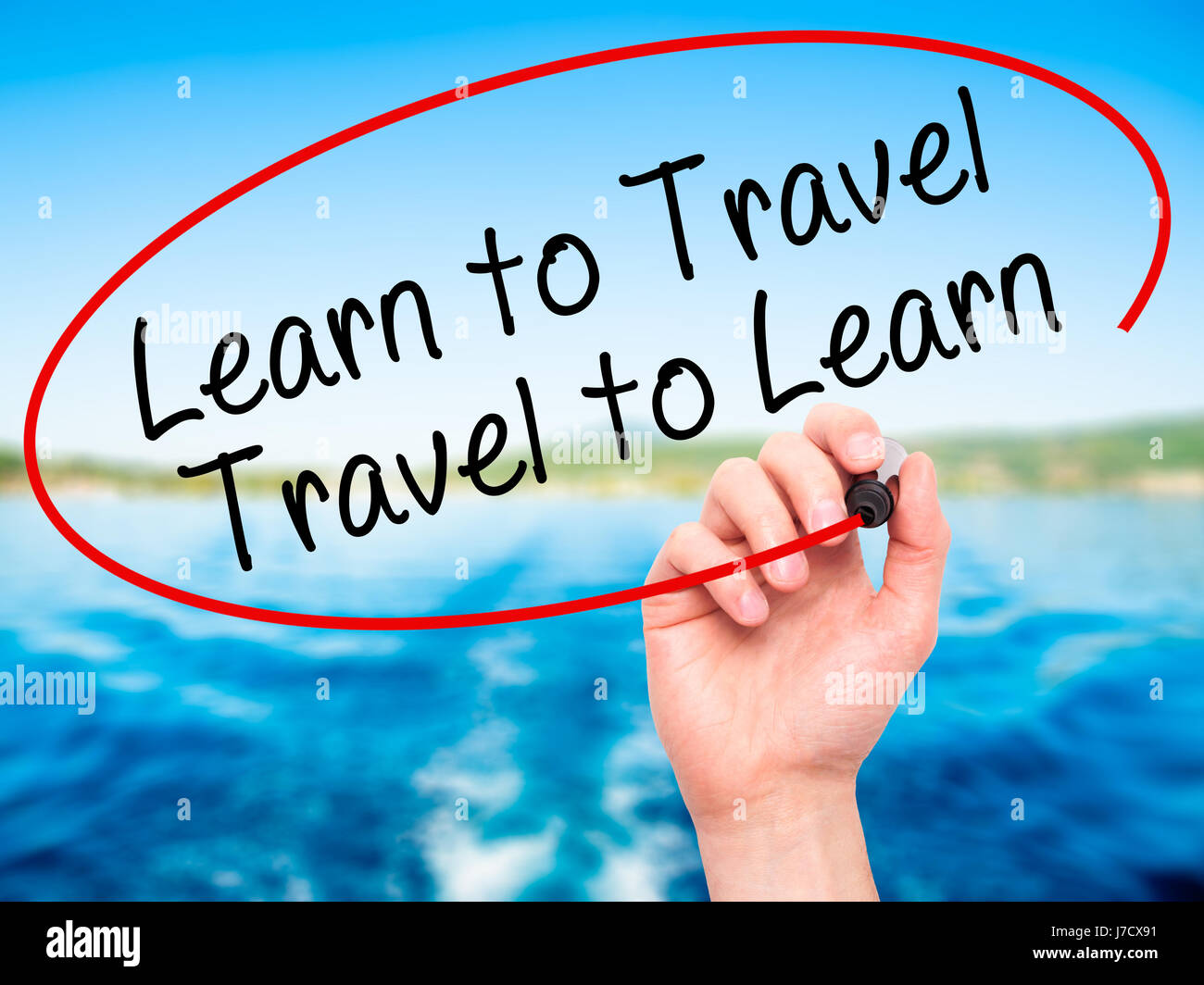 Man Hand writing Learn to Travel. Travel to Learn with black marker on ...