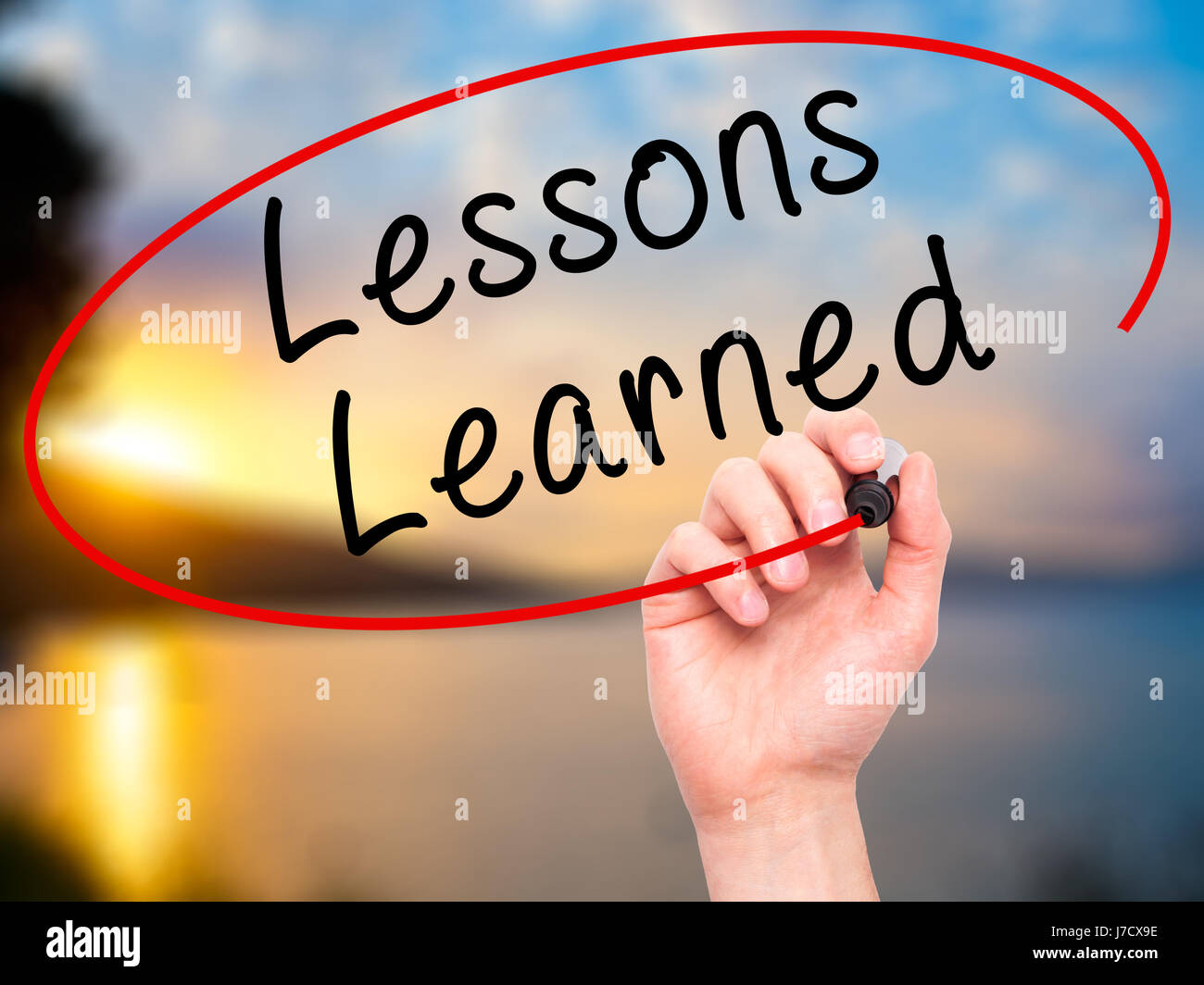 Man Hand writing Lessons Learned with black marker on visual screen ...