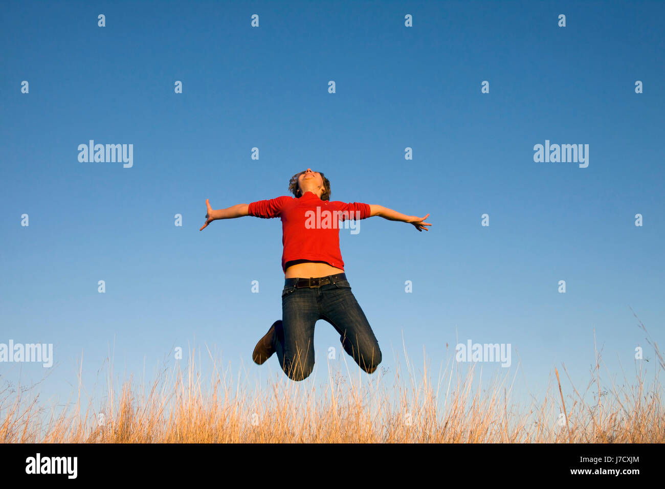 woman spring bouncing bounces hop skipping frisks jumping jump meadow ...