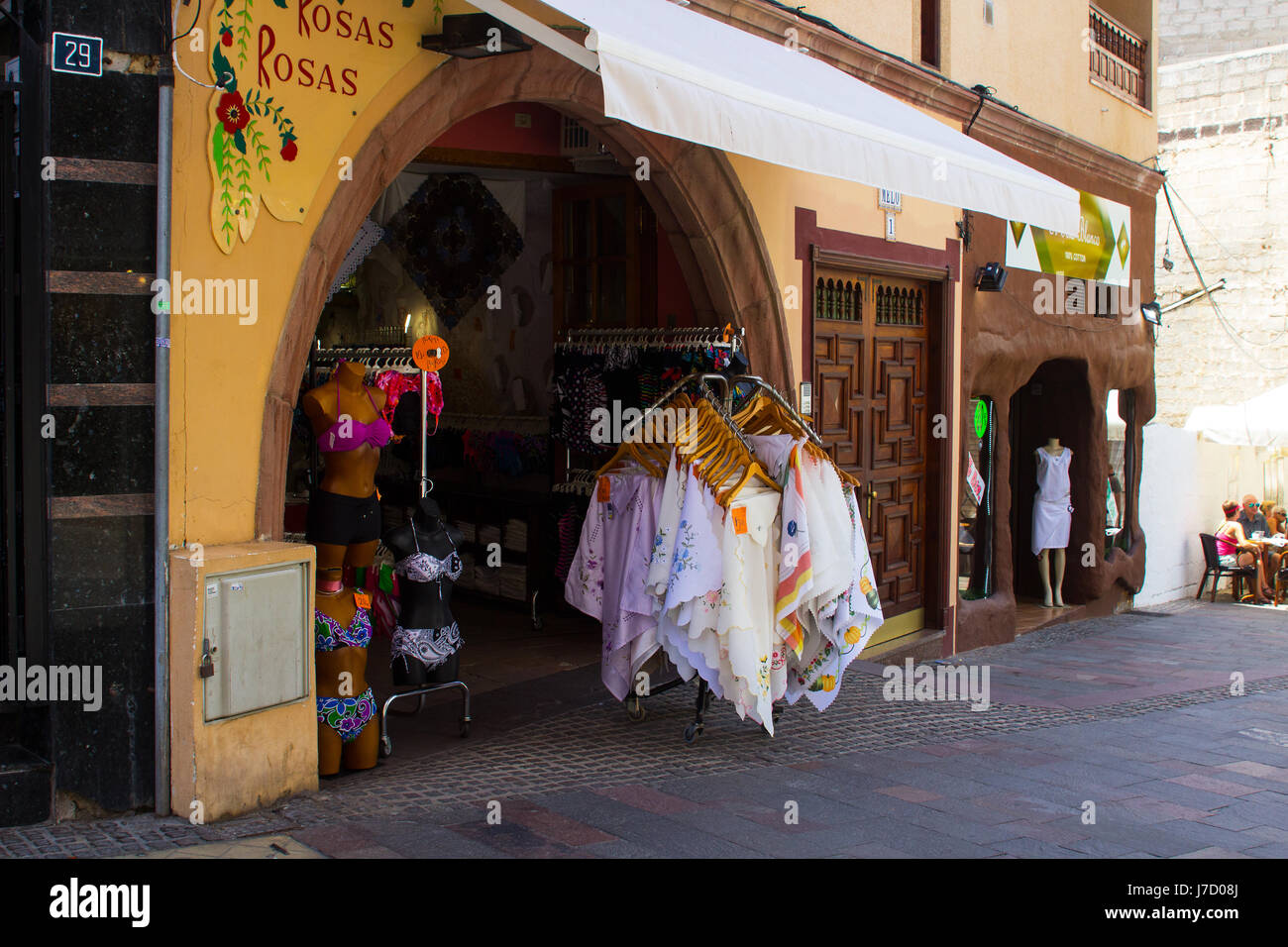 A typical ladies fashion shop with street displays and inviting archway ...