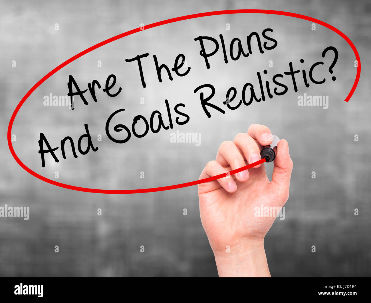 Man Hand writing Are The Plans And Goals Realistic? with black marker ...