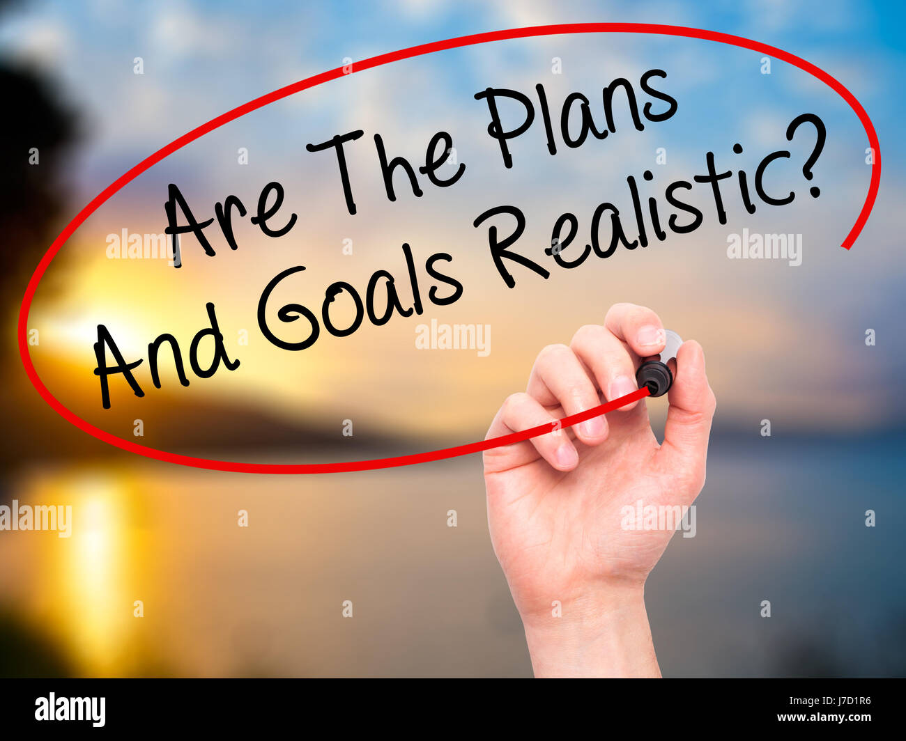 Man Hand writing Are The Plans And Goals Realistic? with black marker ...