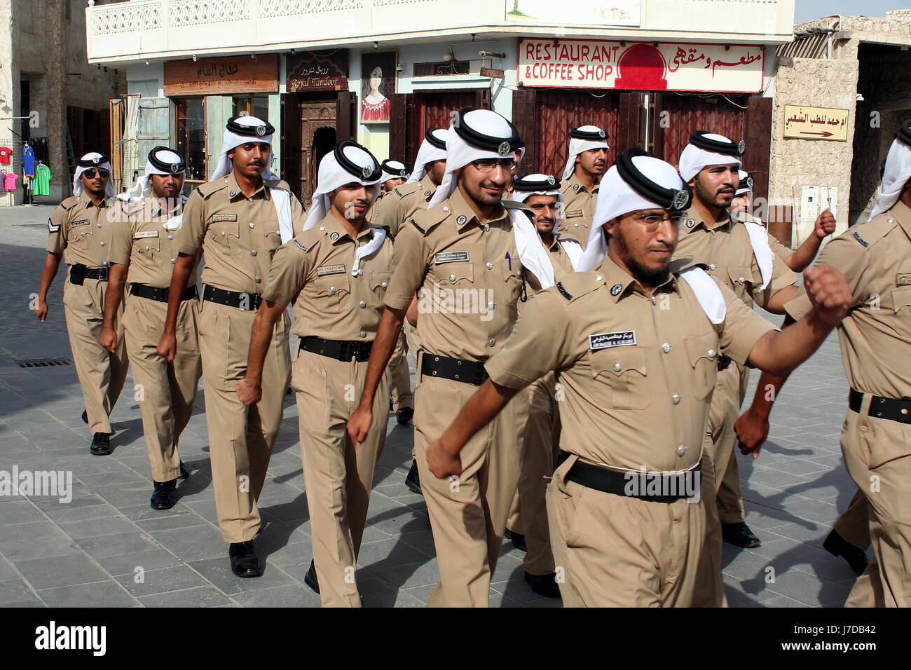 A squad of Qatari policemen marching in the Souq Waqif of Doha, Qatar ...