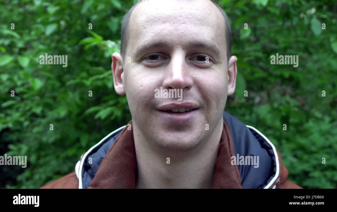 Closeup of happy young man smiing, green background Stock Photo - Alamy