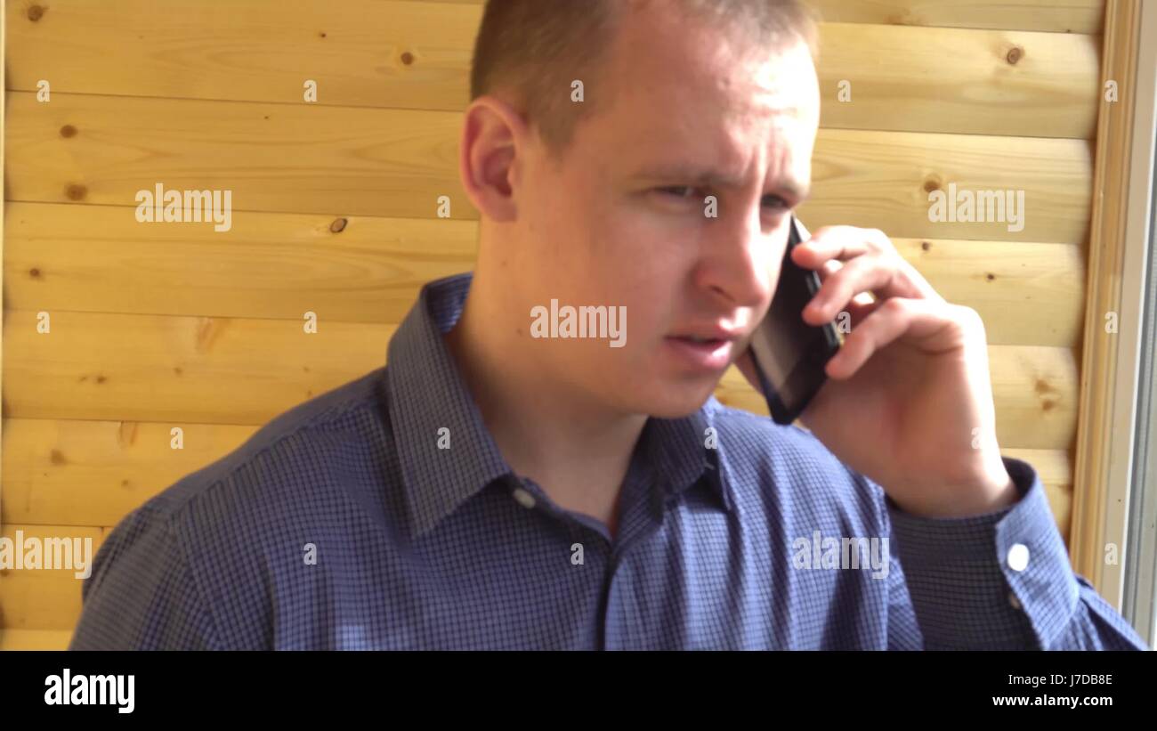 Angry and furious businessman yelling into two phones Stock Photo - Alamy