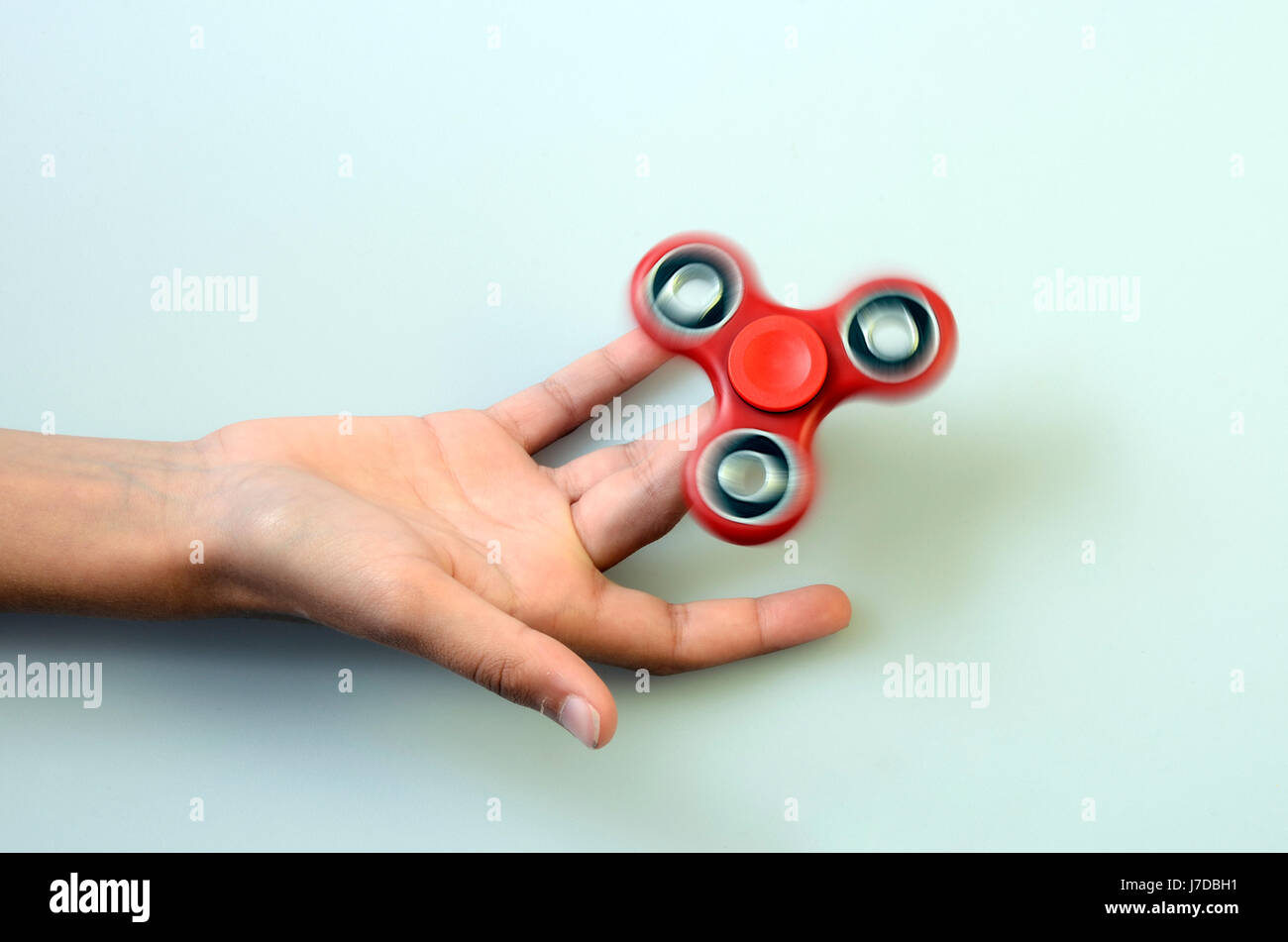 red Hand spinner, fidgeting hand toy rotating on child's finger Stock ...