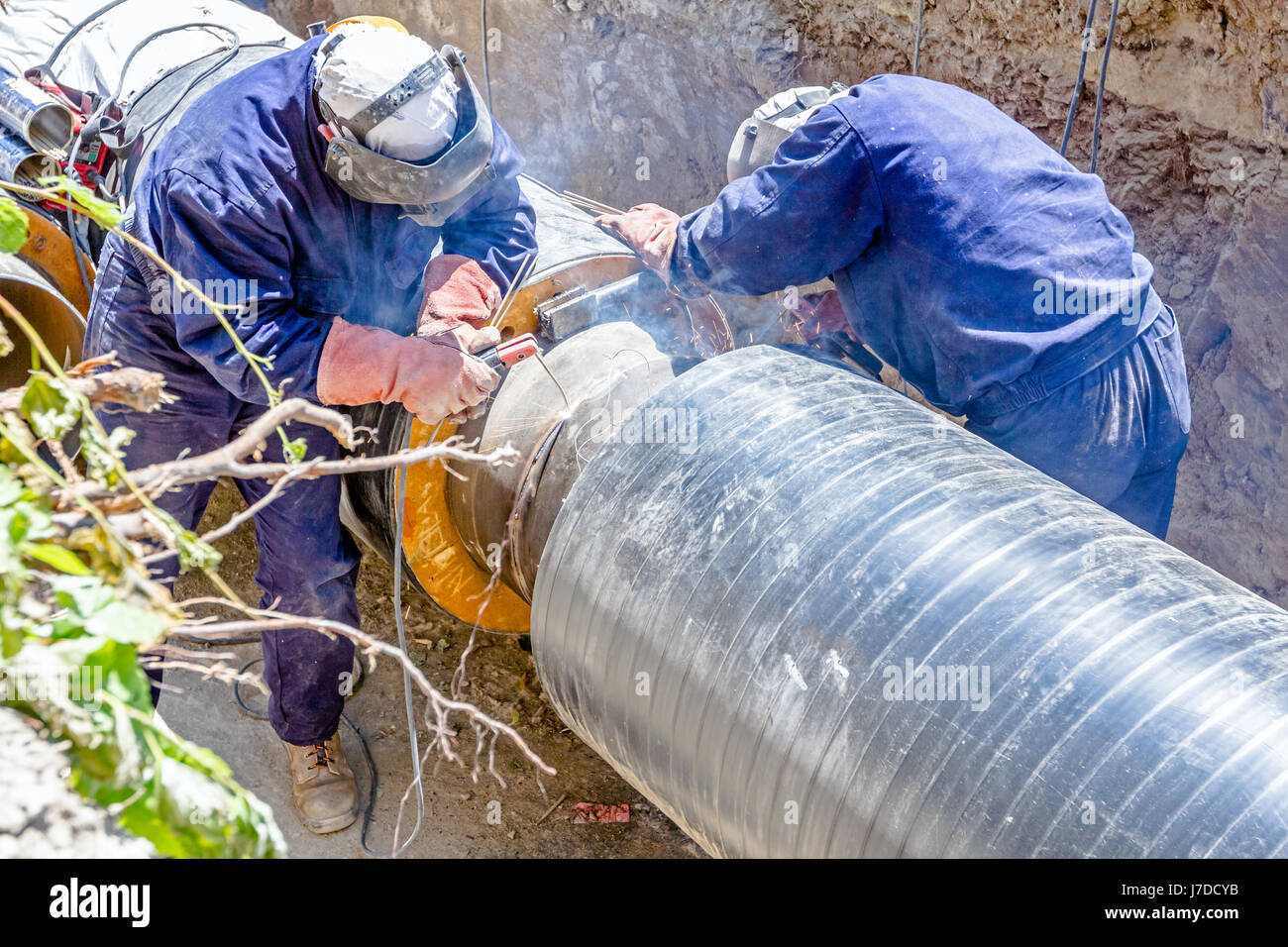 Team of welders is in trench working hard to install a new pipeline ...