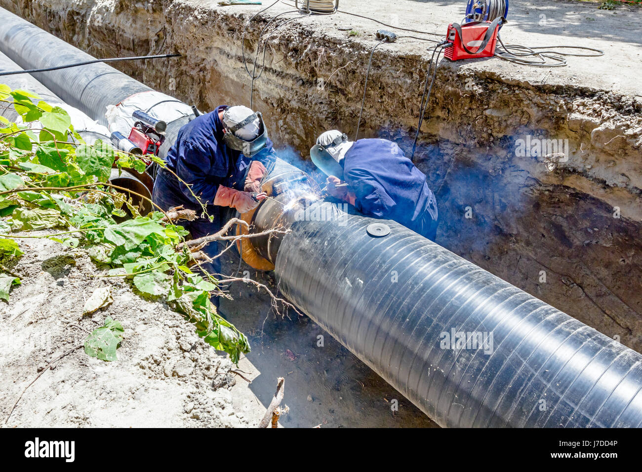 Team of welders is in trench working hard to install a new pipeline ...