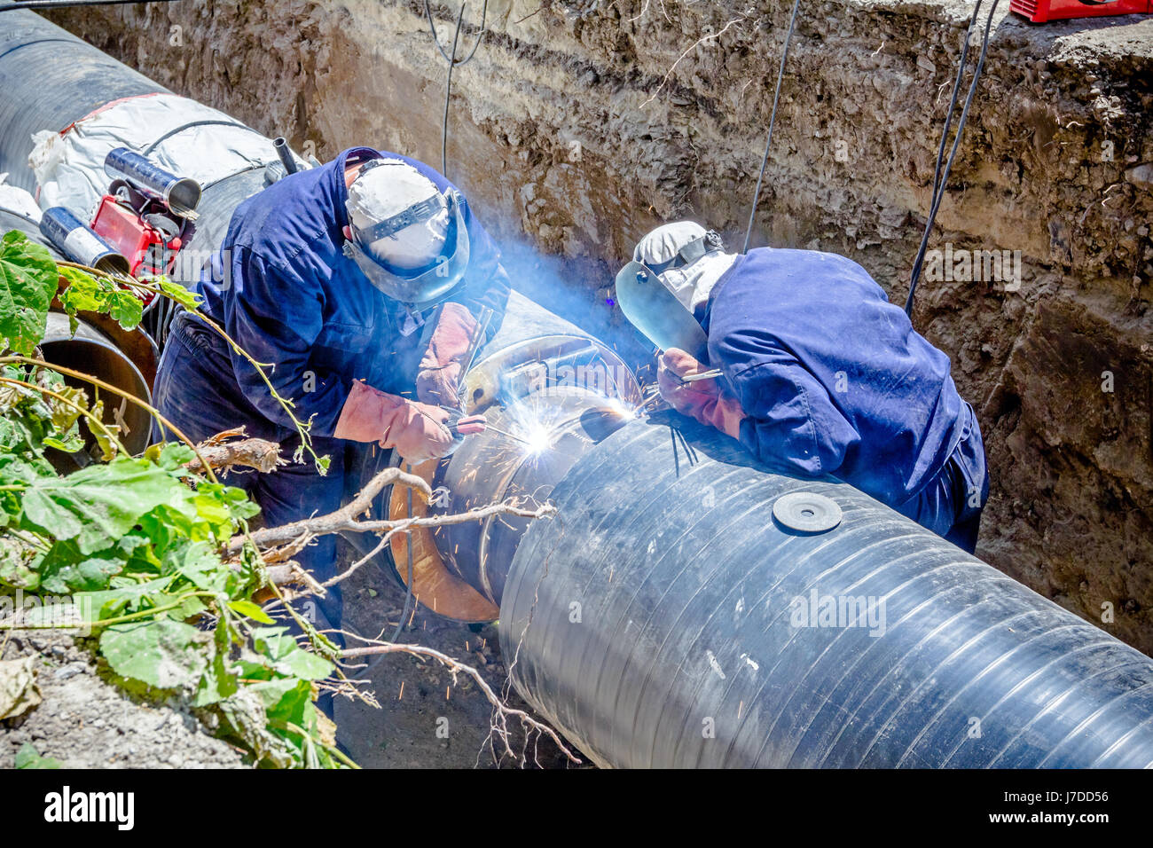 Team of welders is in trench working hard to install a new pipeline ...