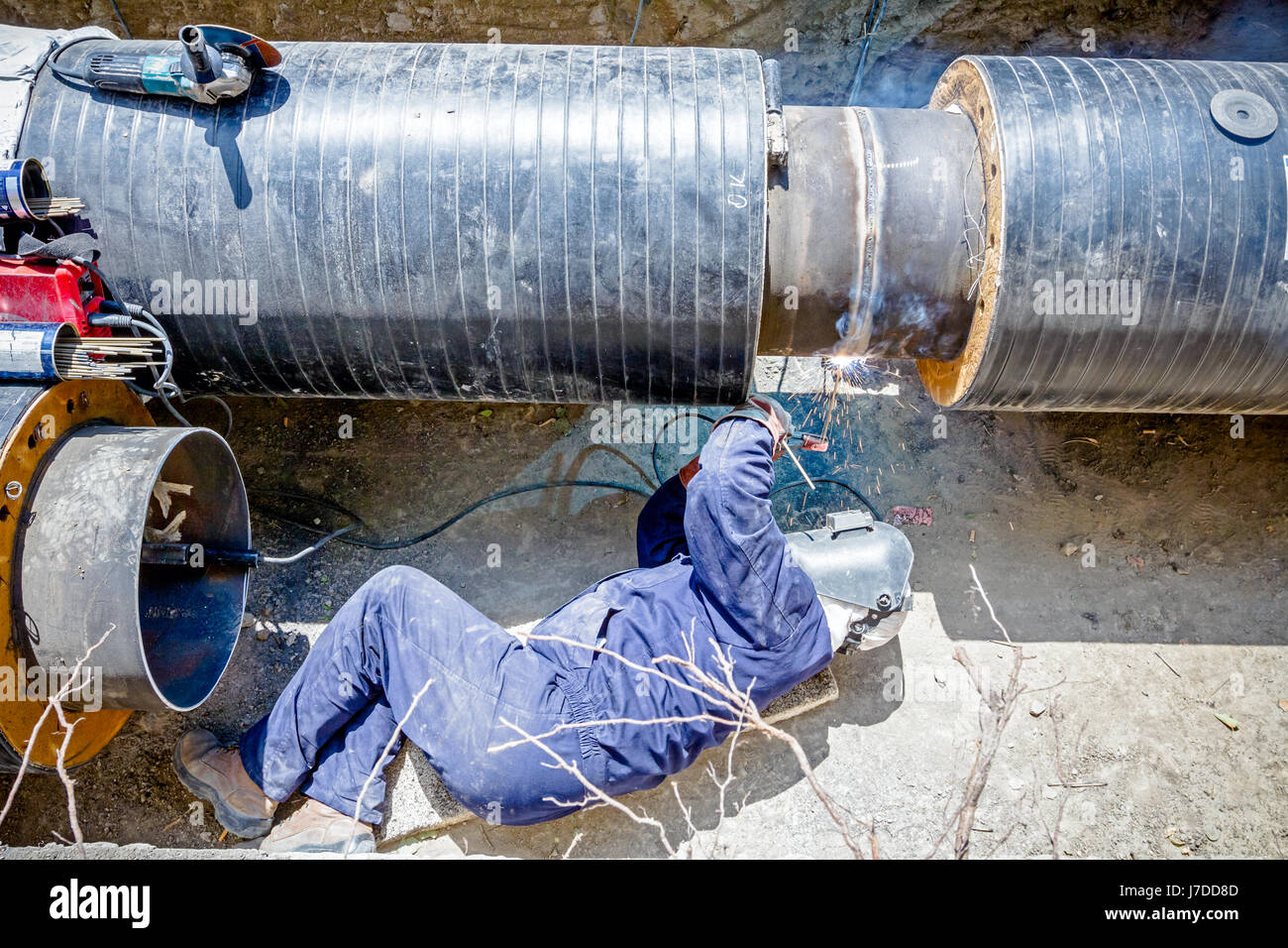 Welder is in trench working hard, arc welding pipeline Stock Photo - Alamy