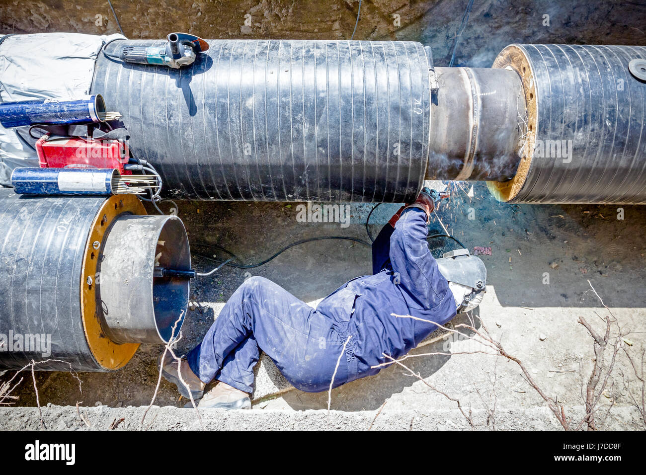 Welder is in trench working hard, arc welding pipeline Stock Photo - Alamy