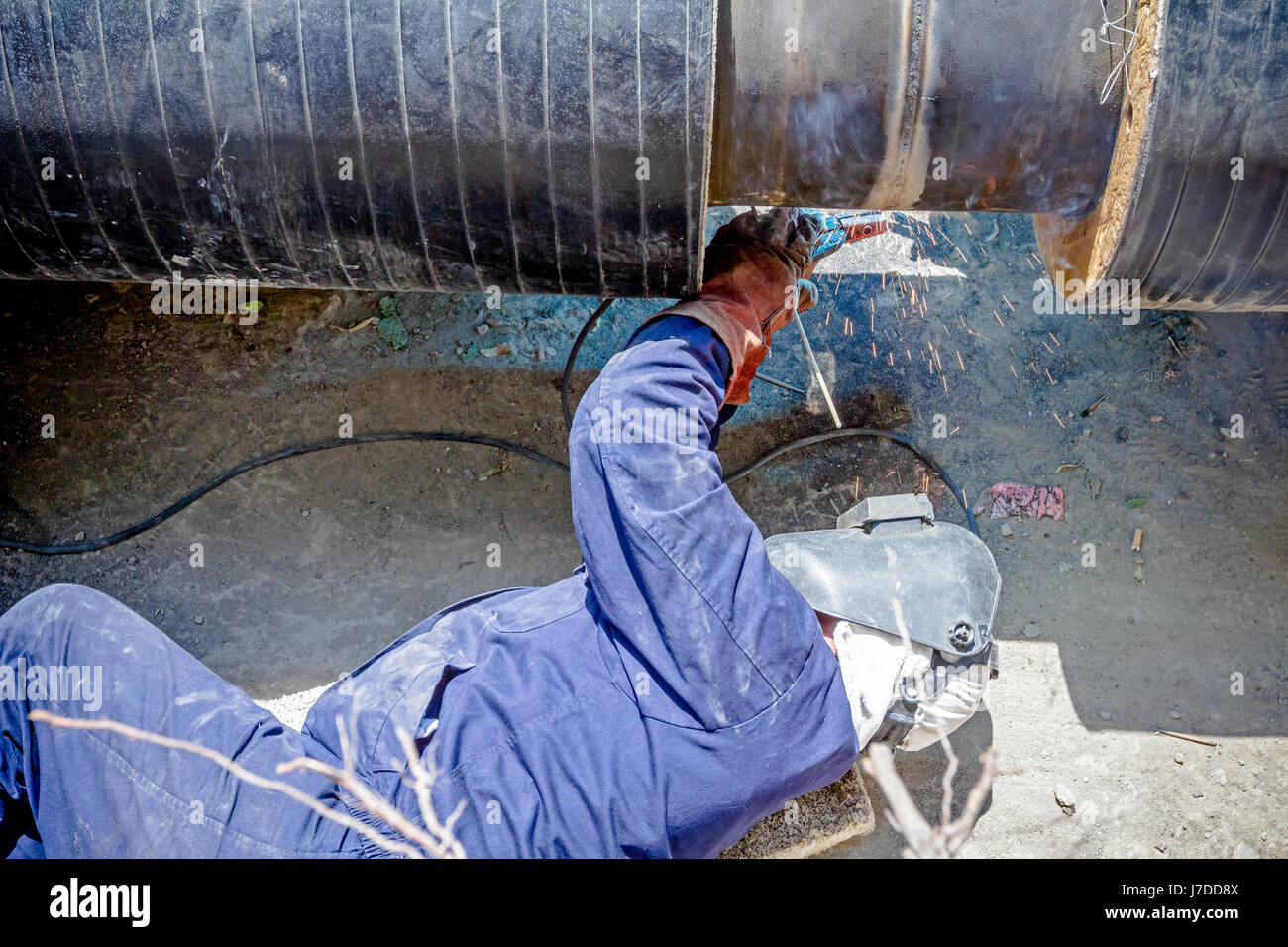 Welder is in trench working hard, arc welding pipeline Stock Photo - Alamy
